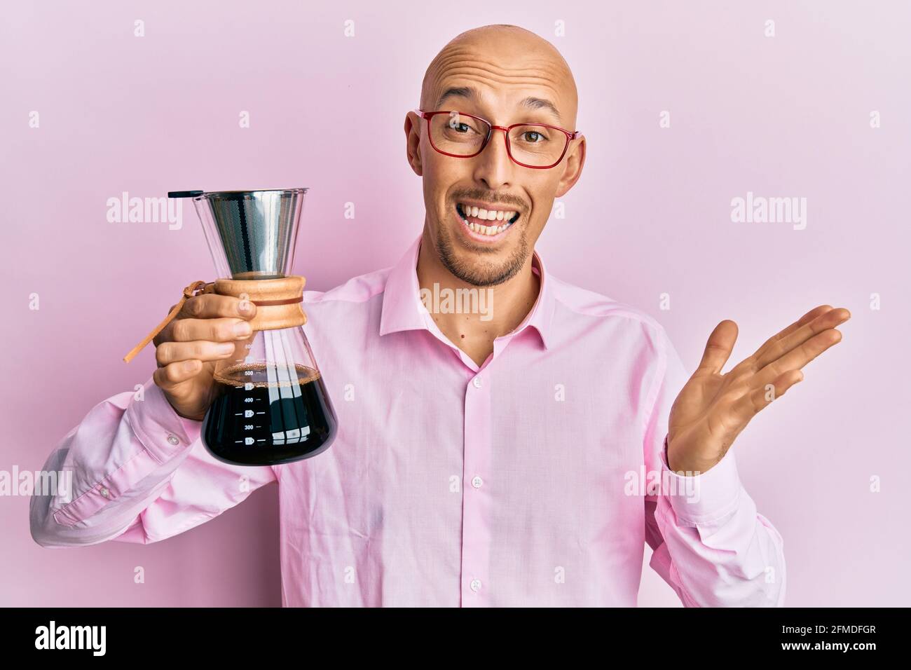 Bald man with beard holding coffee maker with filter celebrating ...