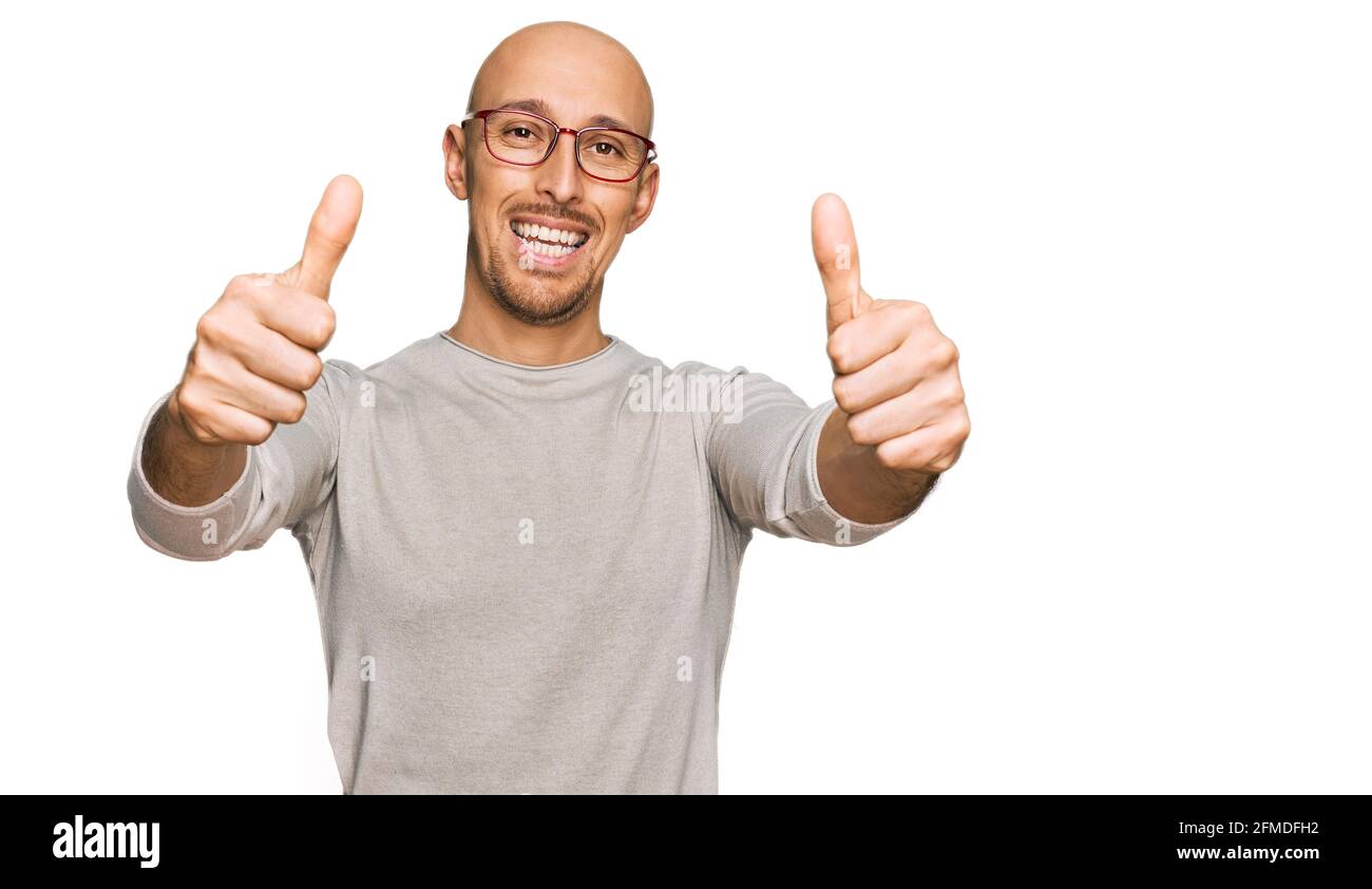 Bald man with beard wearing casual clothes and glasses approving doing ...