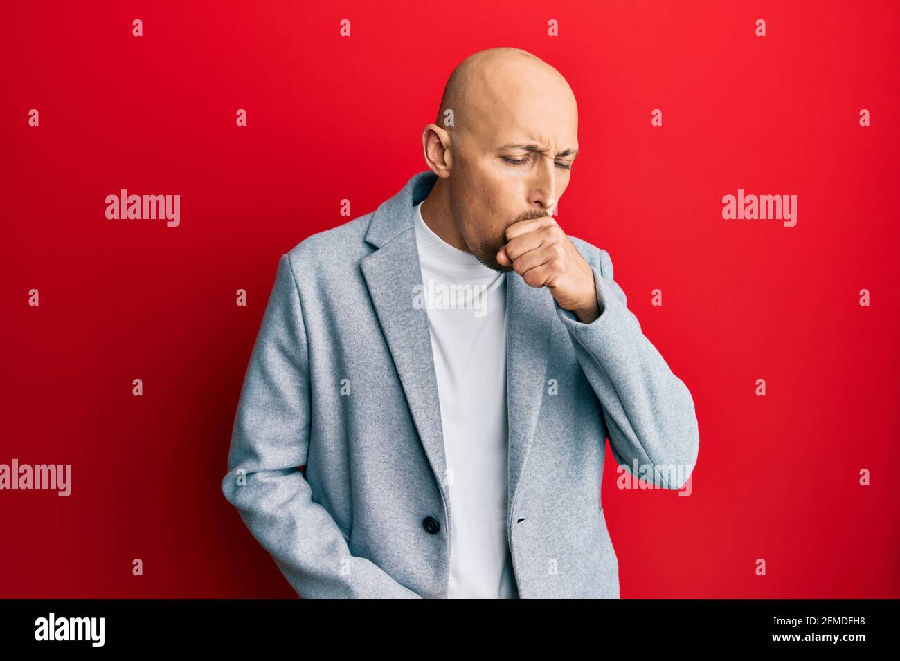 Bald man with beard wearing business jacket feeling unwell and coughing ...