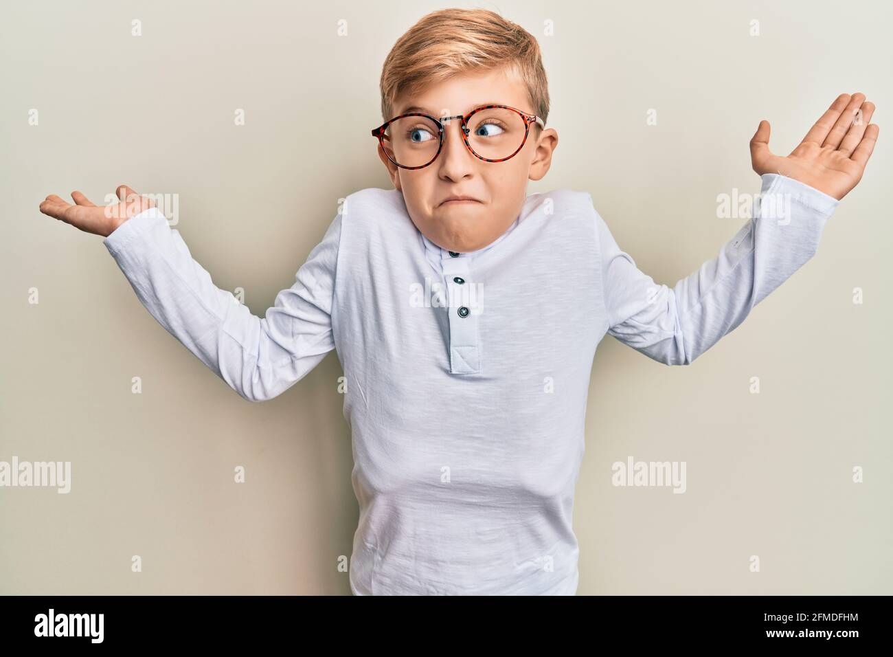 Little caucasian boy kid wearing casual clothes and glasses clueless ...