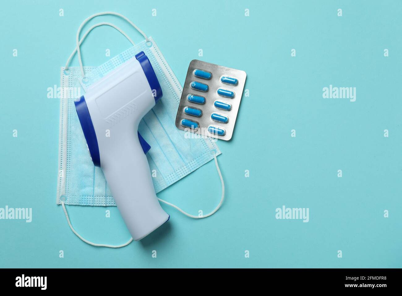 Medical tools and thermometer gun on blue background Stock Photo - Alamy