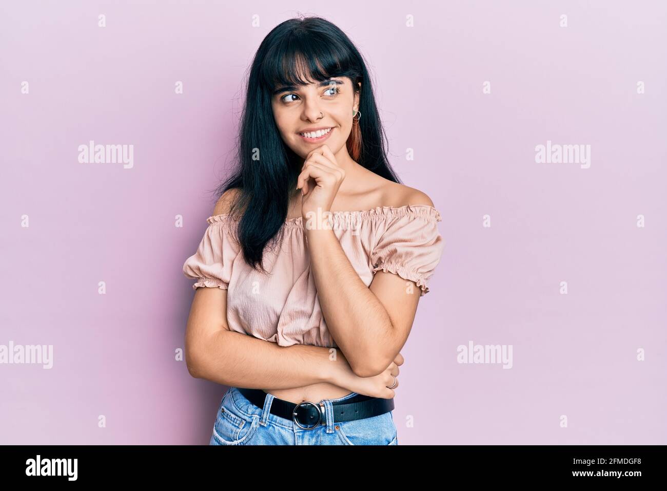 Young hispanic girl wearing casual clothes with hand on chin thinking ...