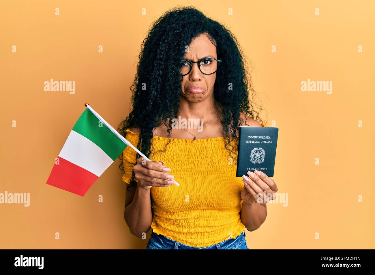 Middle age african american woman holding italy flag and passport ...