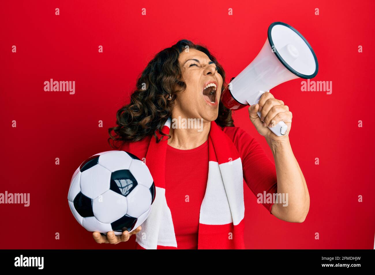 Middle age hispanic woman hooligan screaming through megaphone ...