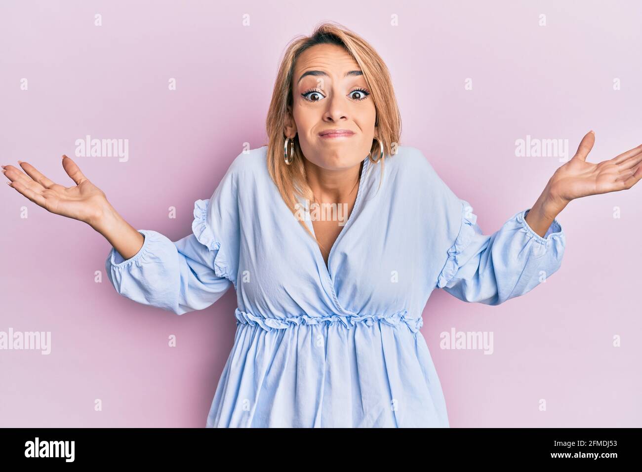Beautiful blonde woman wearing summer dress clueless and confused with ...