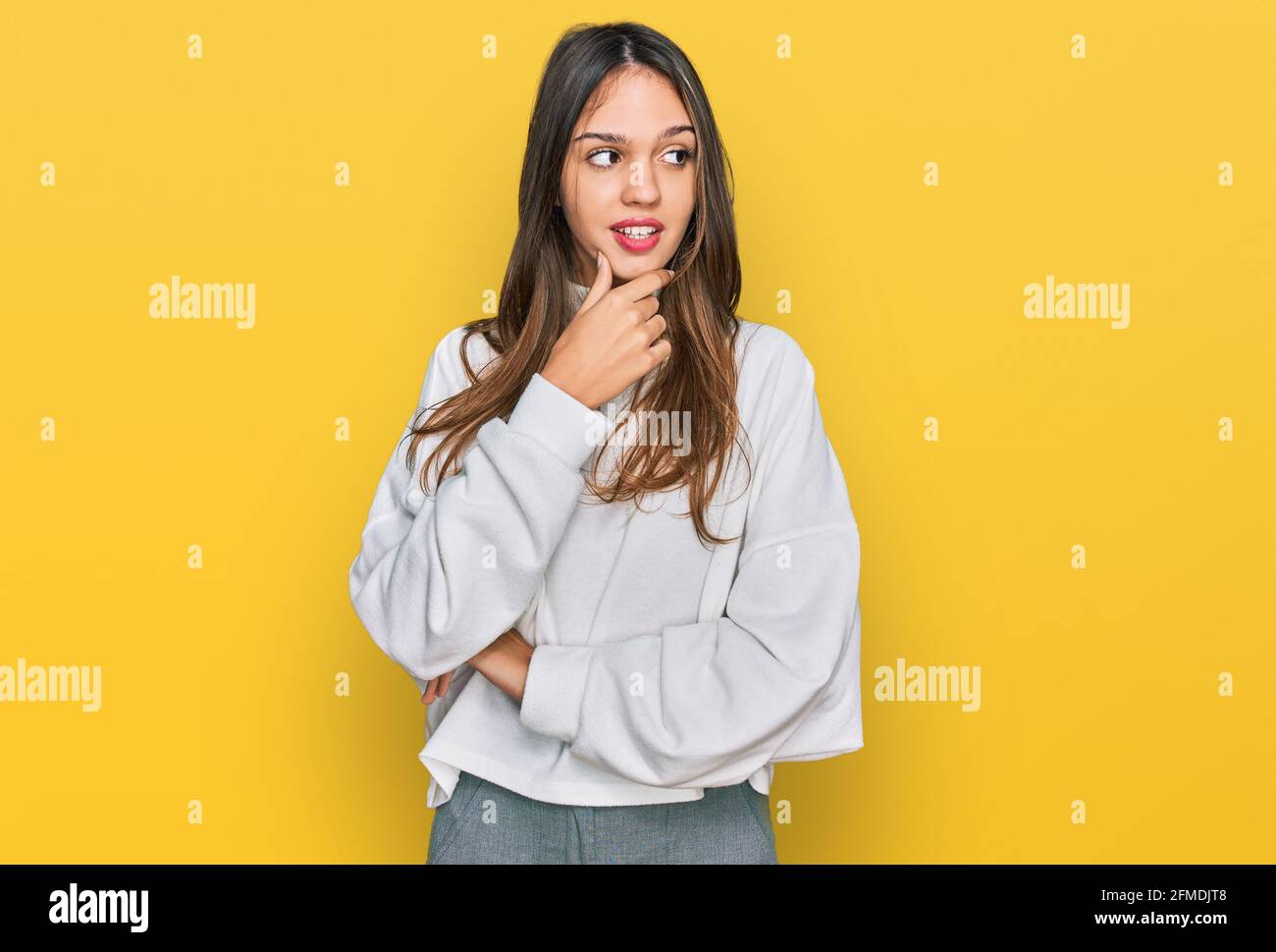 Young brunette woman wearing casual turtleneck sweater with hand on ...