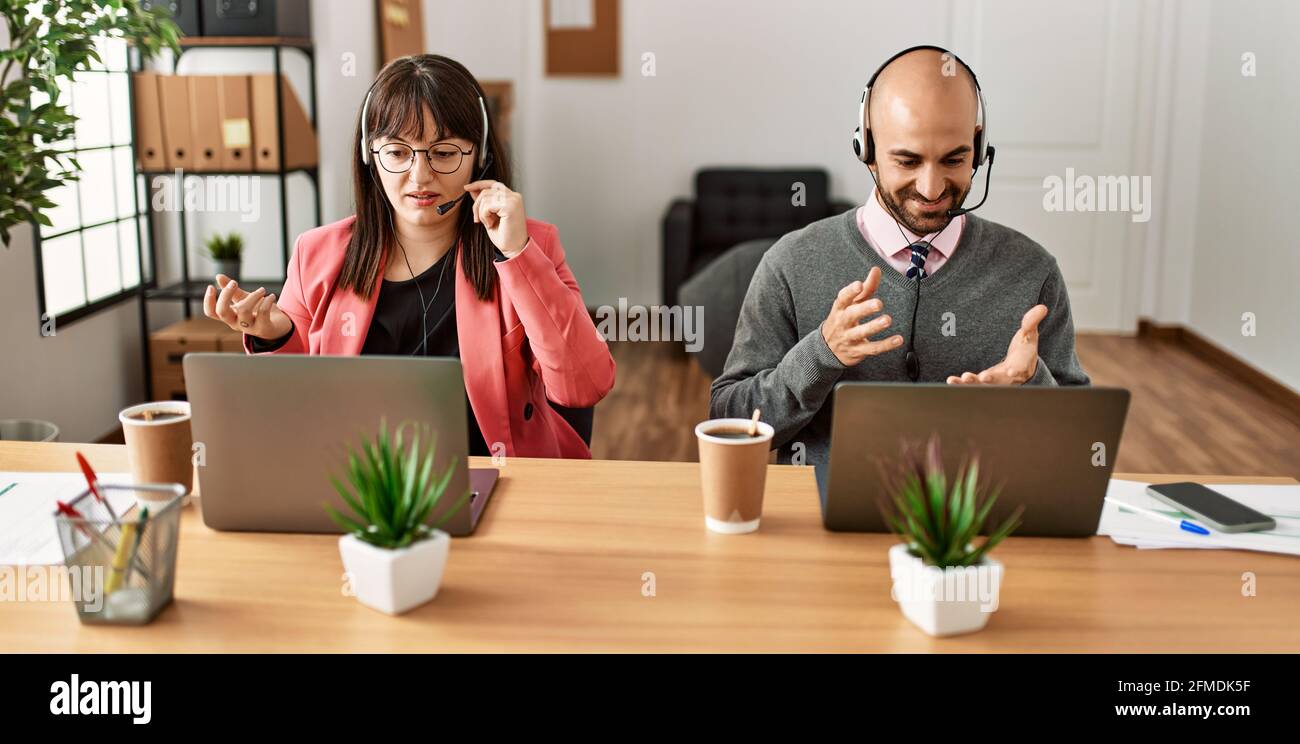 Two call center agent smiling happy having video call using laptop at ...