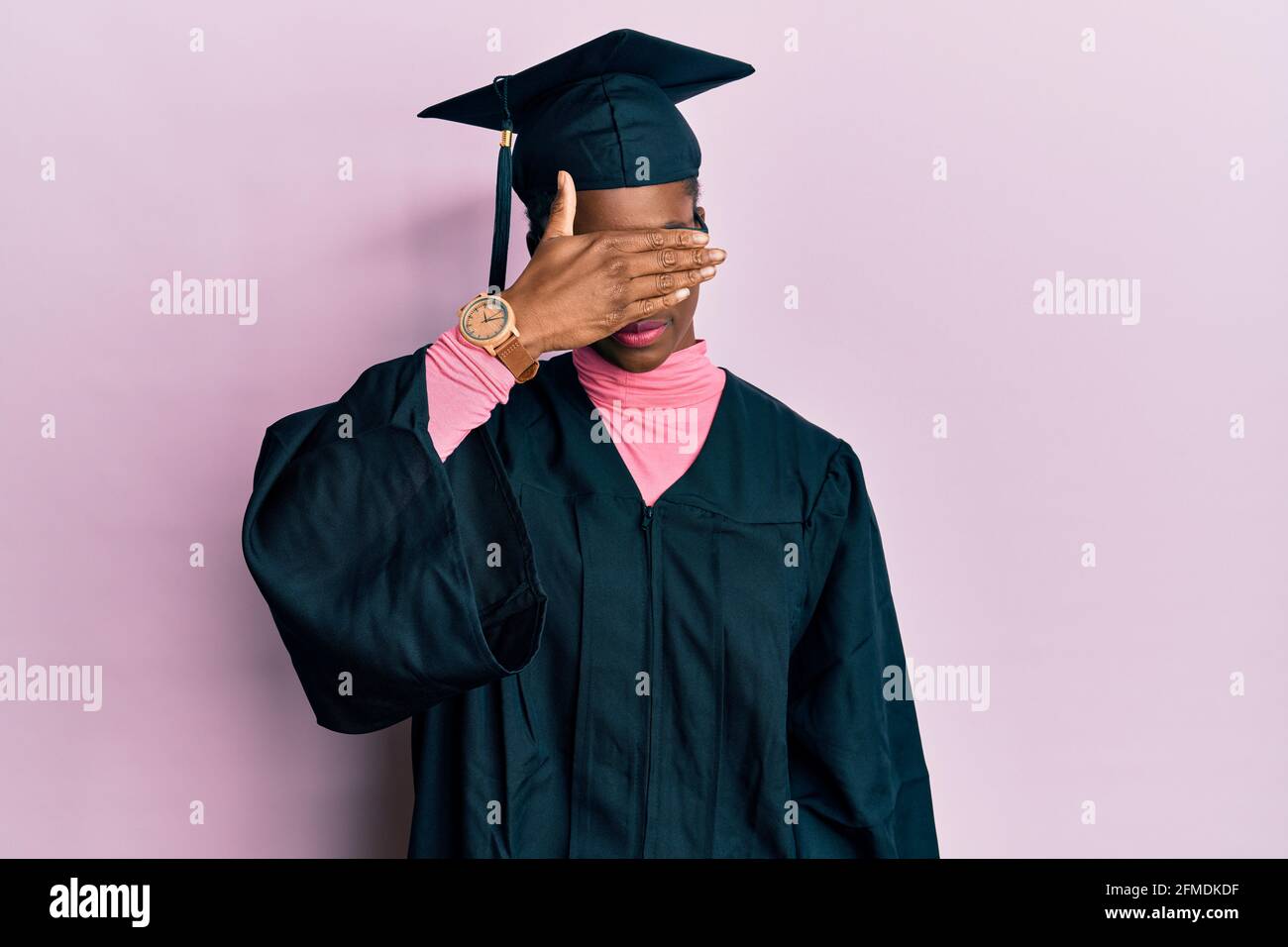 Young african american girl wearing graduation cap and ceremony robe ...
