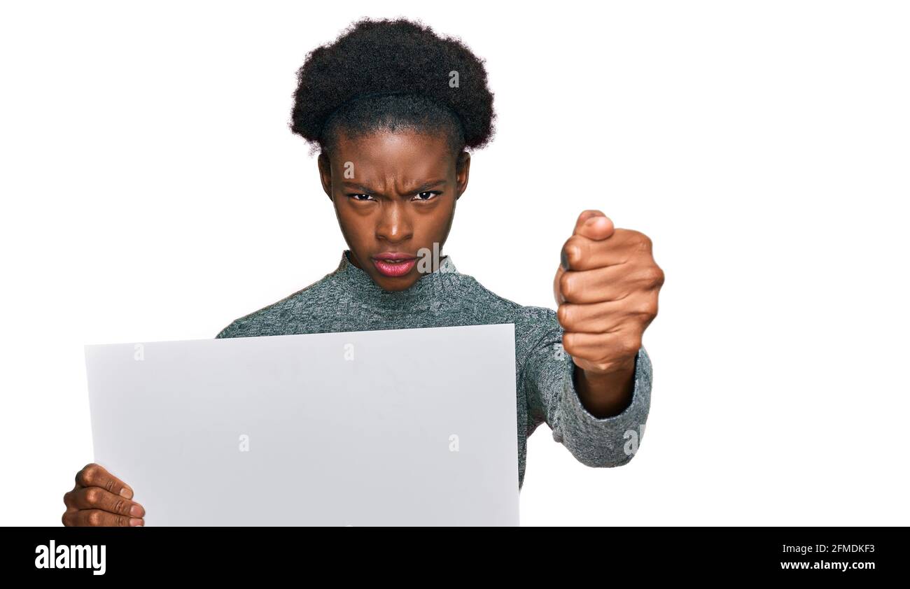 Young african american girl holding blank empty banner annoyed and ...