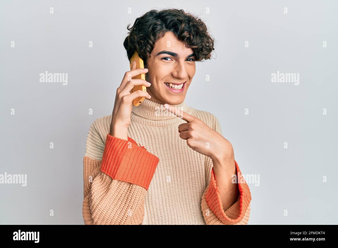 Hispanic young man having conversation talking on the smartphone ...