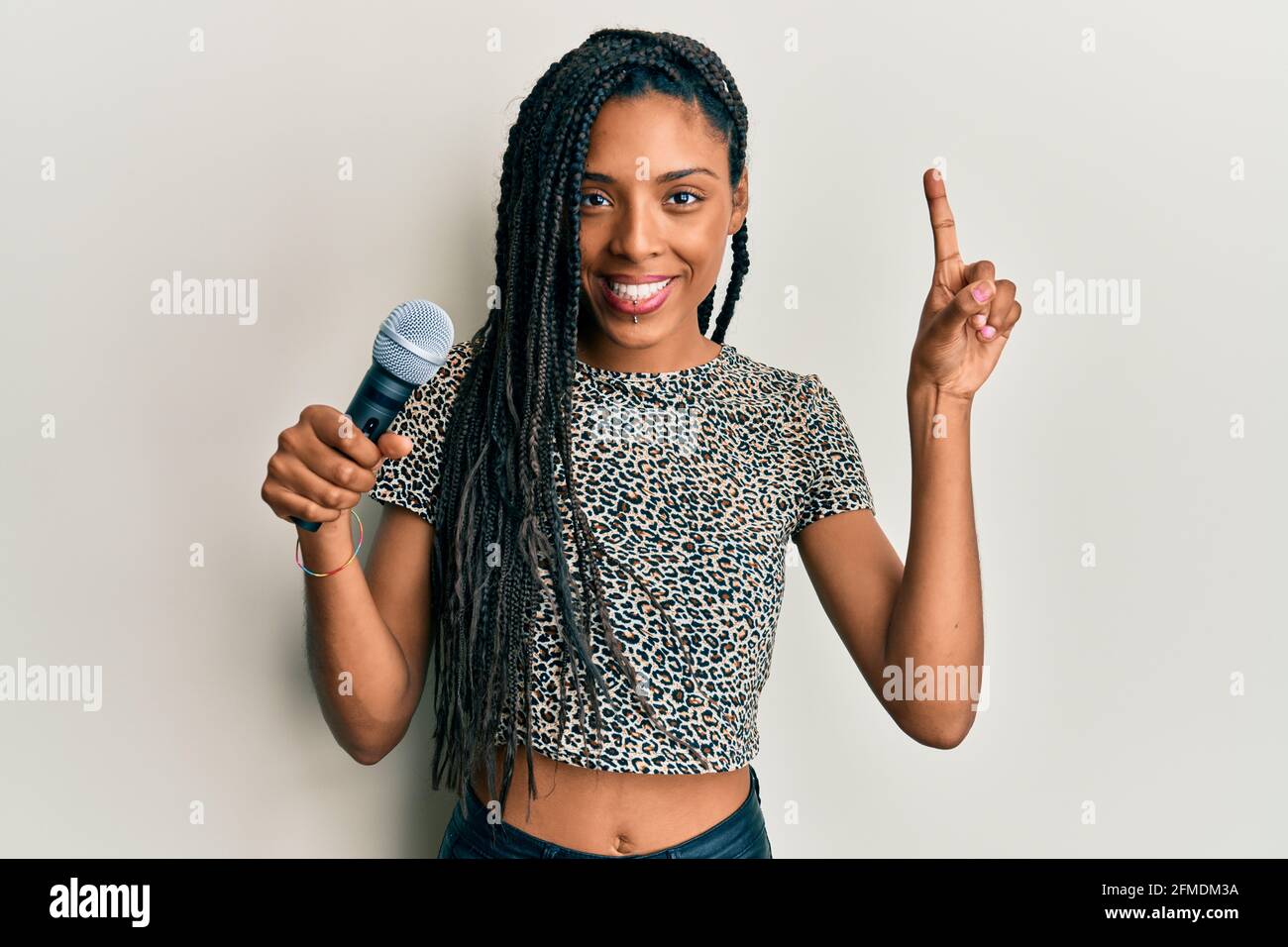 African american woman singing song using microphone smiling with an ...