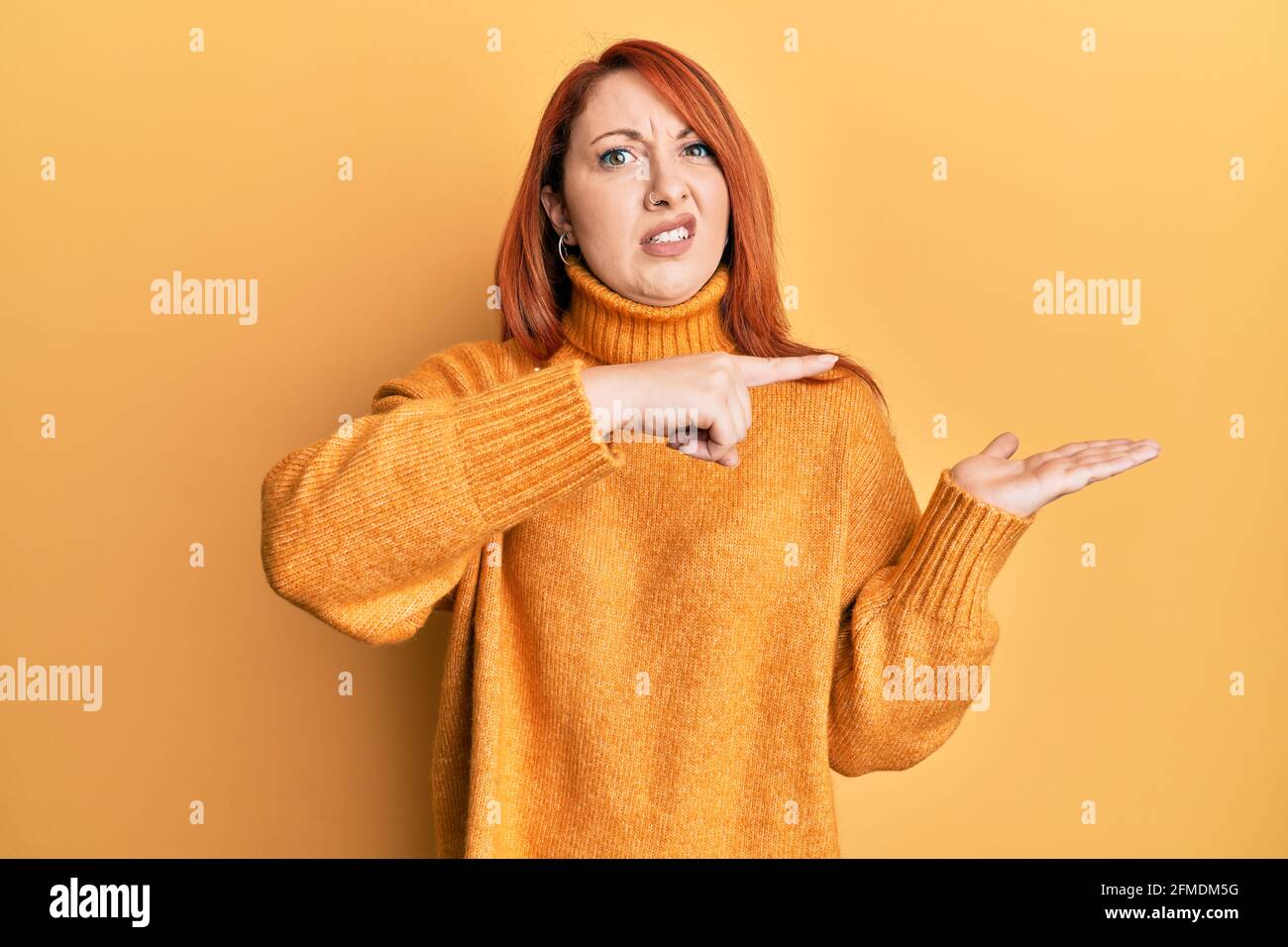 Beautiful redhead woman pointing with finger to empty space on open ...