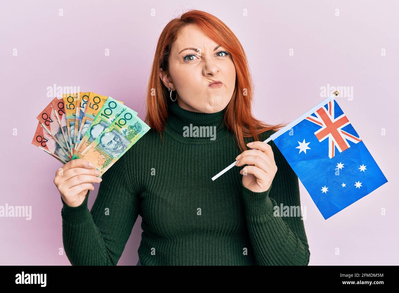 Beautiful redhead woman holding australian dollars and australia flag ...