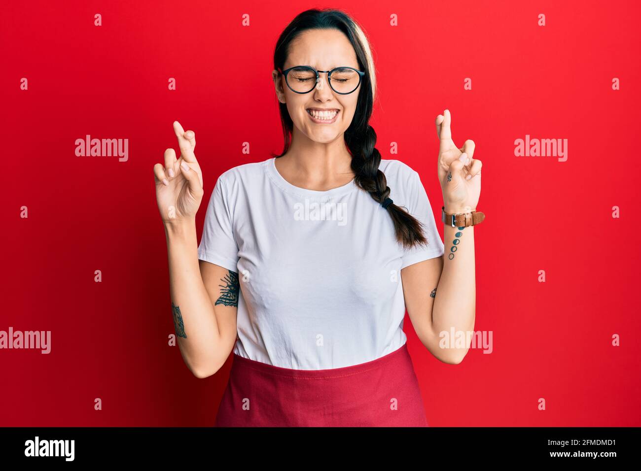 Young hispanic woman wearing professional waitress apron gesturing ...
