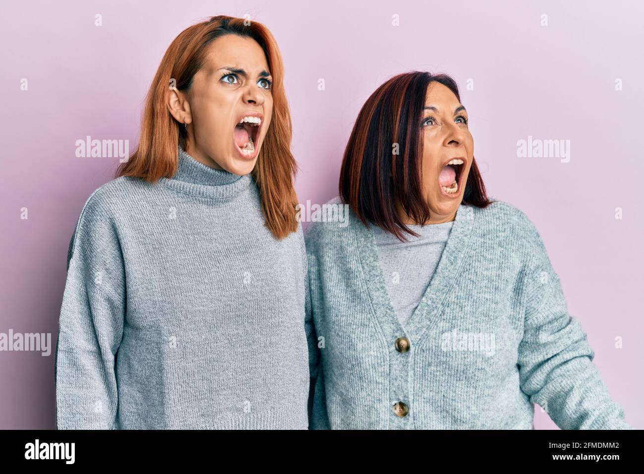 Latin mother and daughter wearing casual clothes angry and mad ...