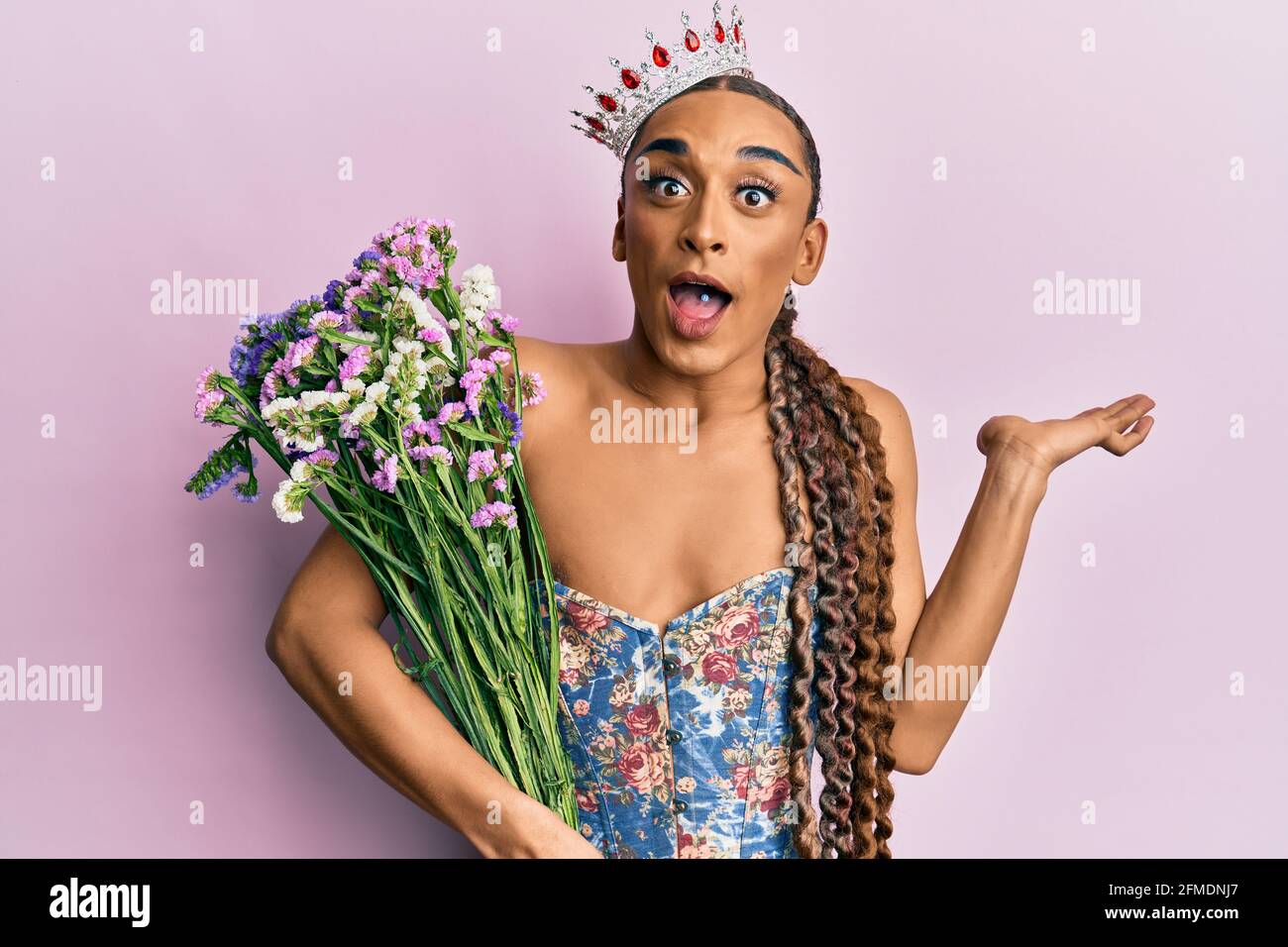 Hispanic man wearing make up and long hair wearing princess crown ...