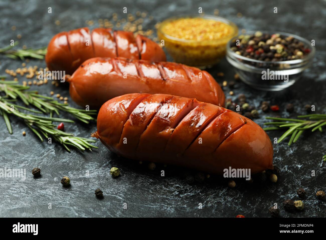 Grilled sausage, mustard and spices on black smokey background Stock ...