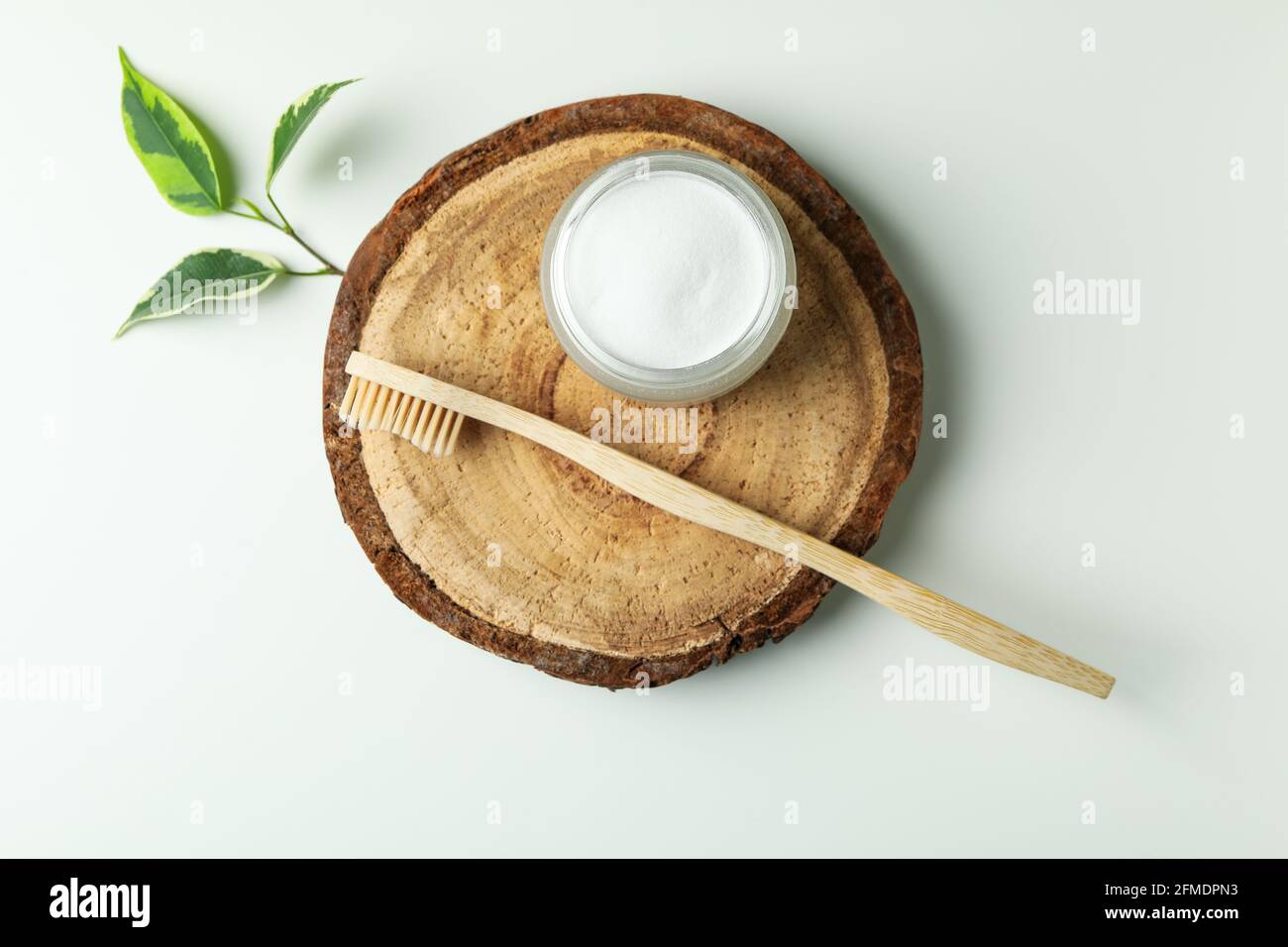 Board with eco friendly toothbrush and tooth powder on white background ...