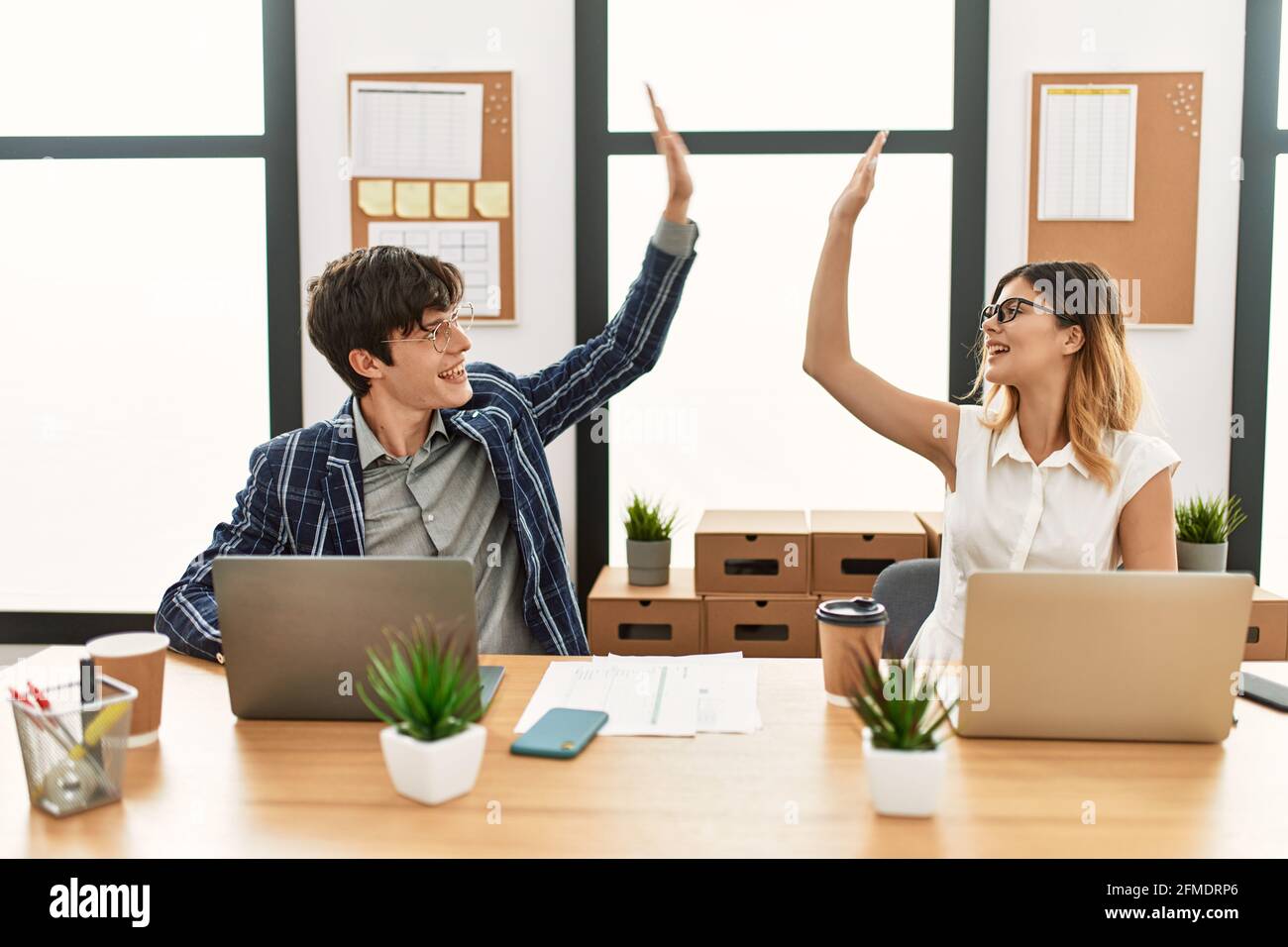 Two business workers smiling happy high five at the office Stock Photo ...