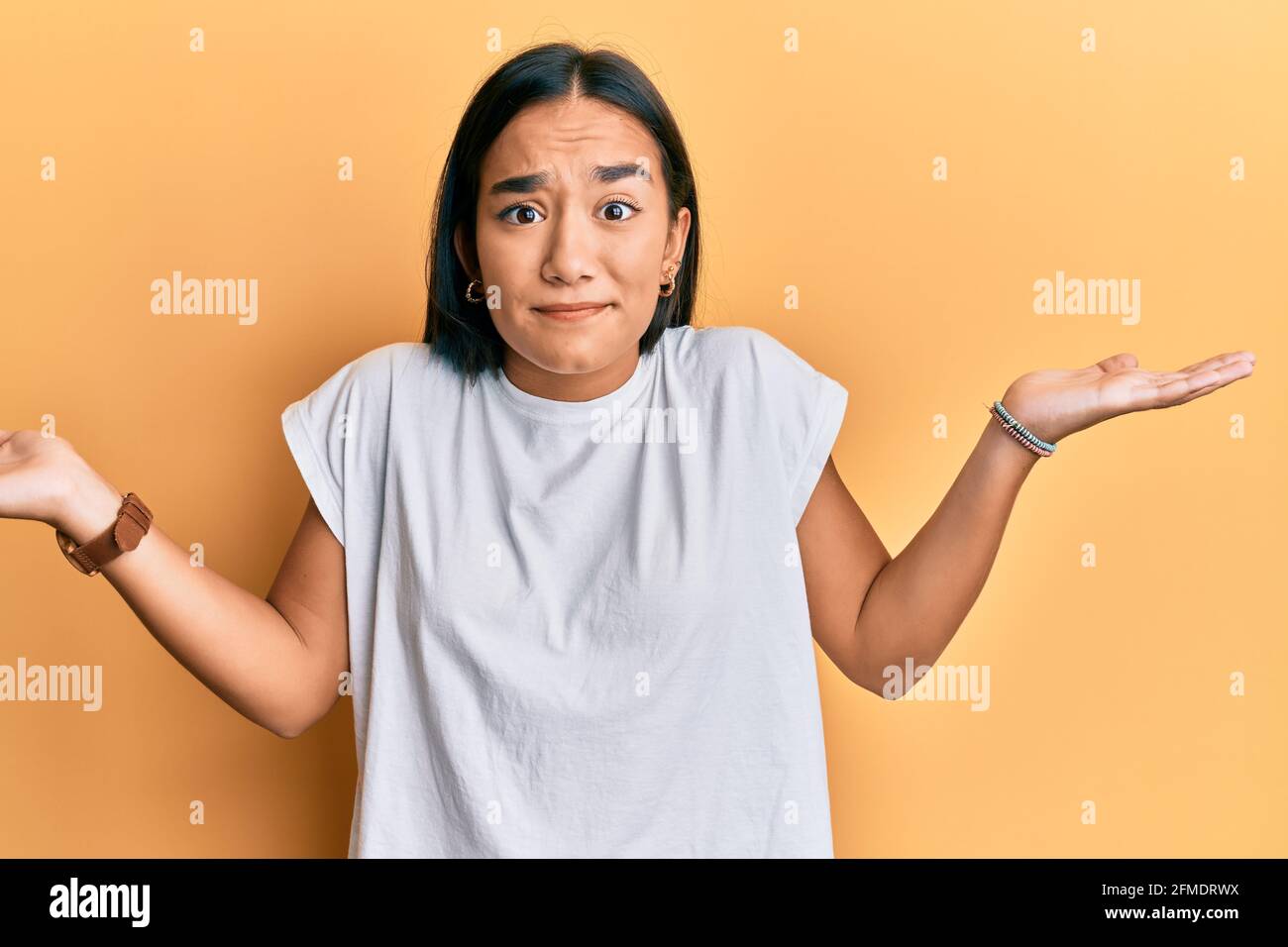 Young asian woman wearing casual white t shirt clueless and confused ...