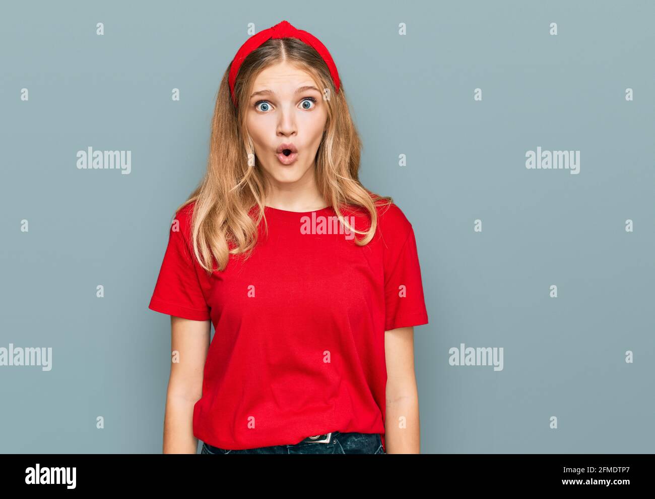 Beautiful young caucasian girl wearing casual red t shirt afraid and ...