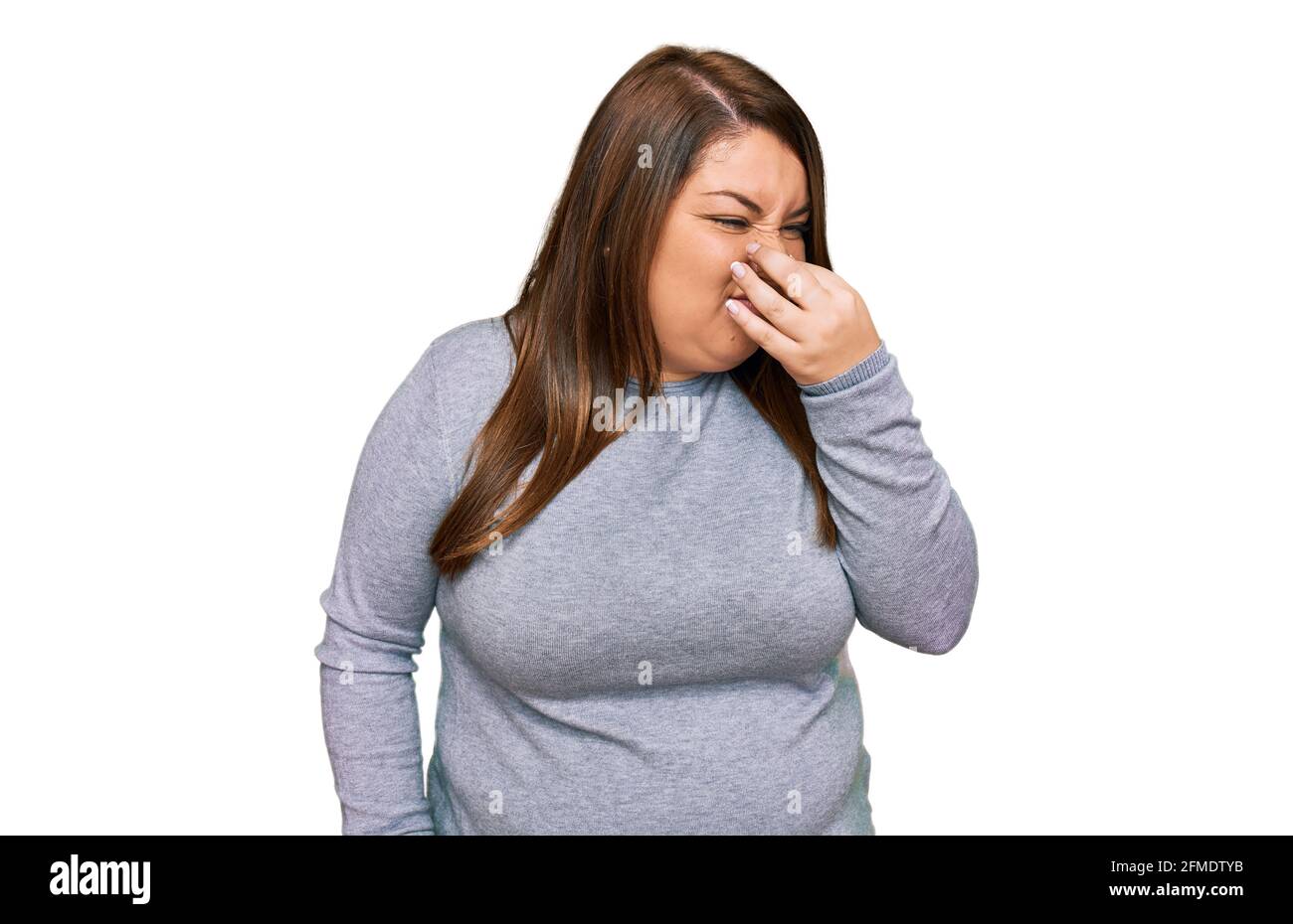 Beautiful brunette plus size woman wearing casual clothes smelling ...