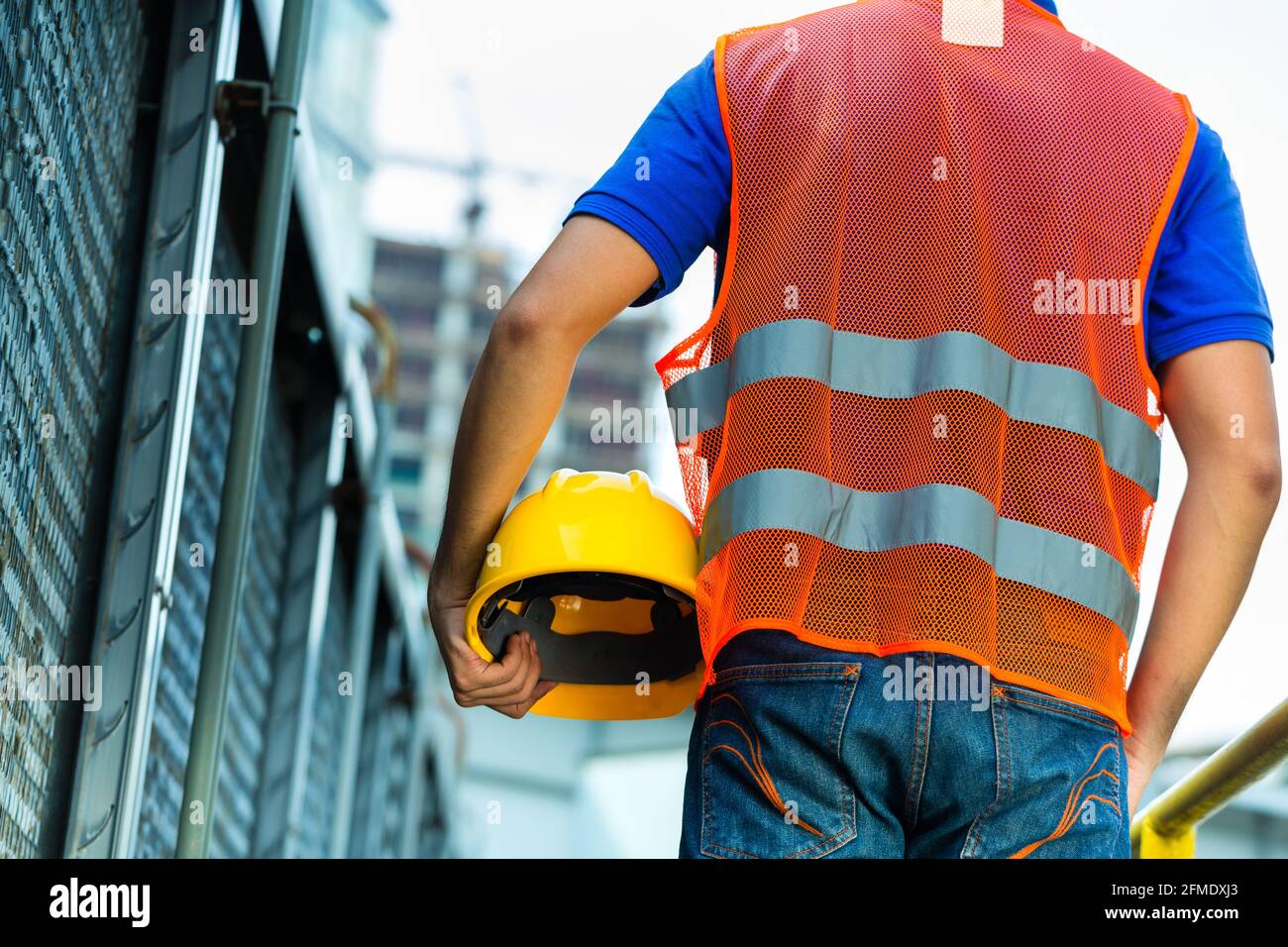 Asian Indonesian construction worker with helmet and safety vest on a ...