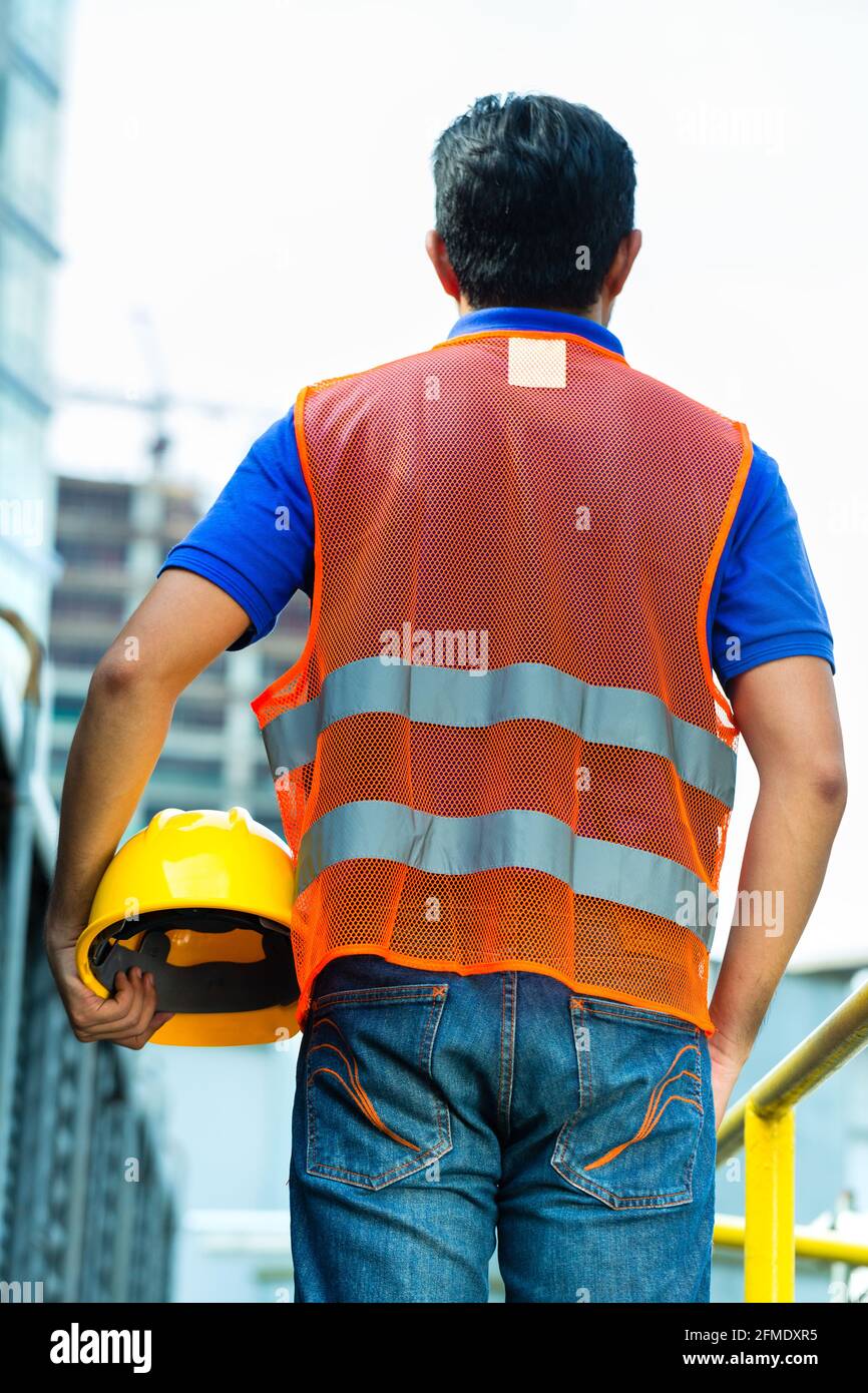 Asian Indonesian construction worker with helmet and safety vest on a ...