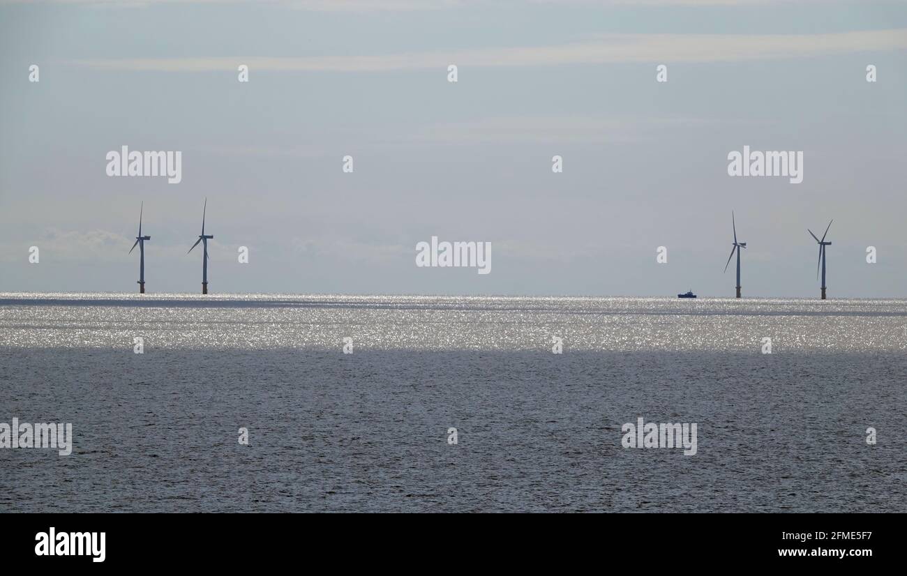 Background of empty sea with shadows of clouds and wind turbines beside ...