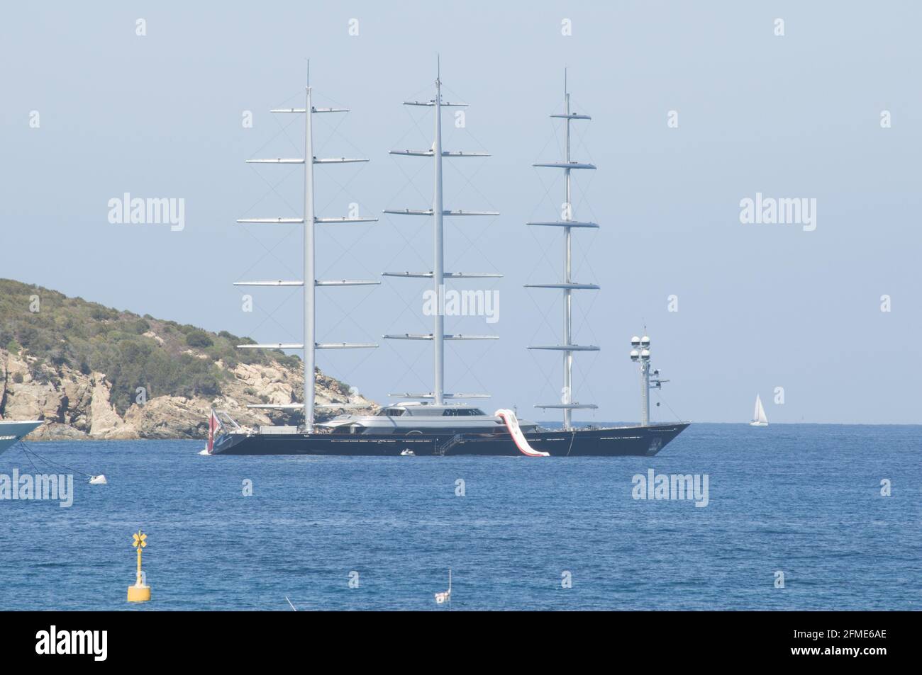 Closeup shot of a sailing yacht with sails down in the blue waters of ...