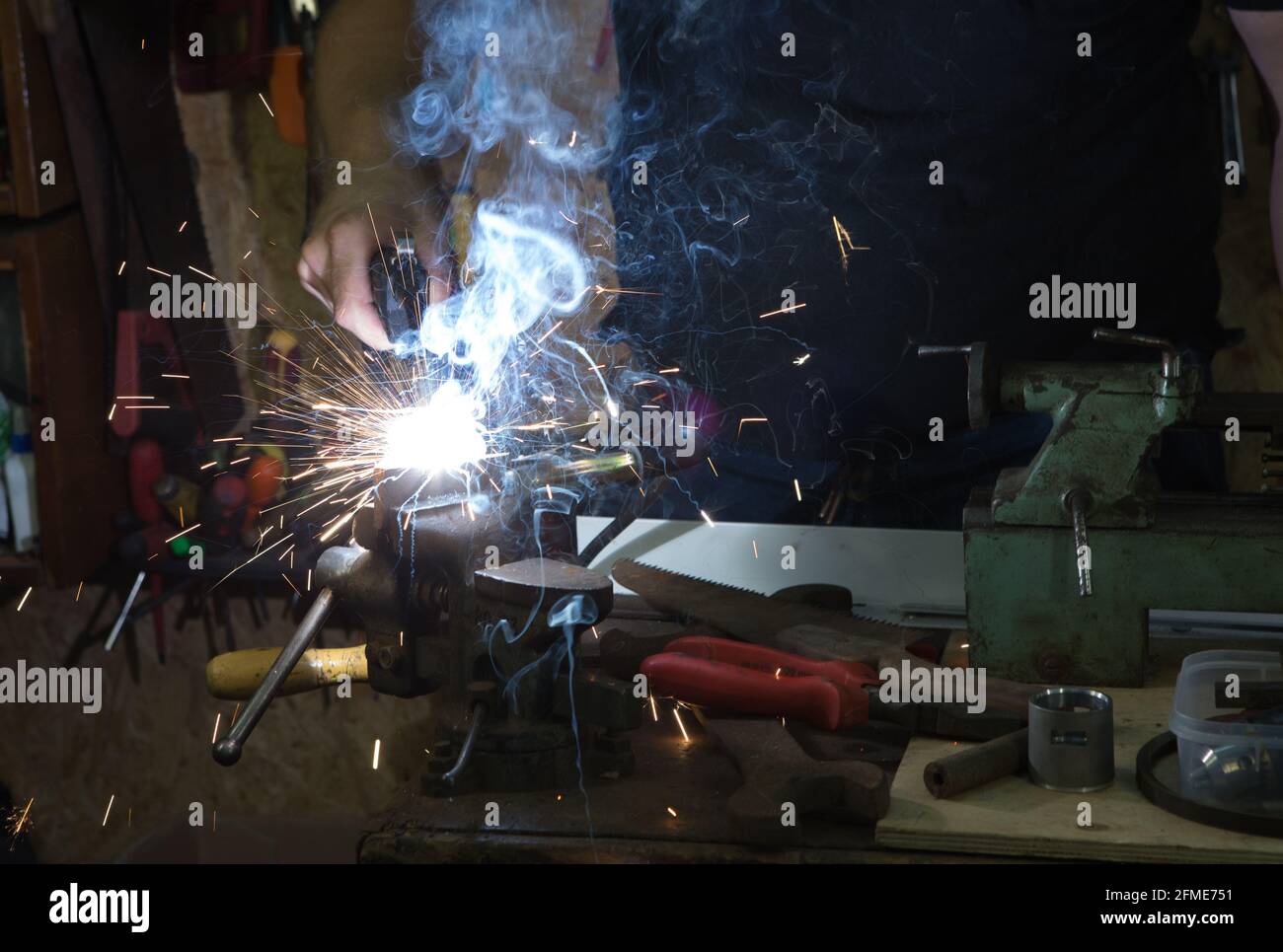 Working with the tool. Hands of a young man working with a welding ...
