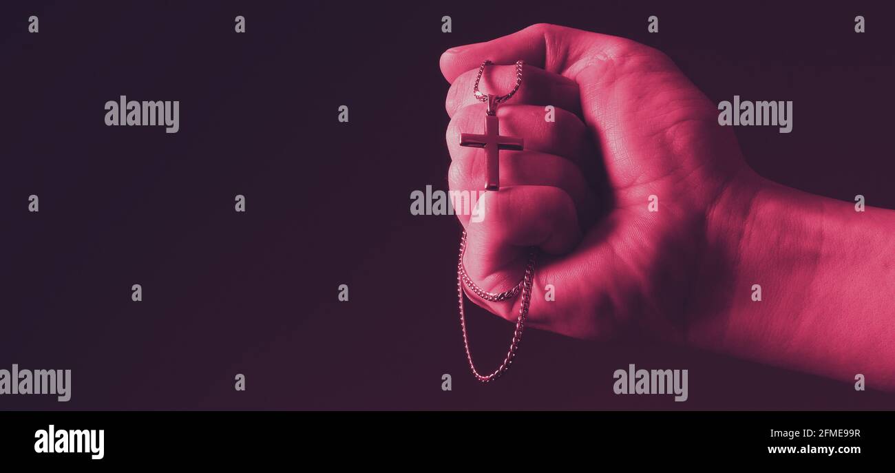 Praying with a rosary. hand of Catholic man with rosary on black ...