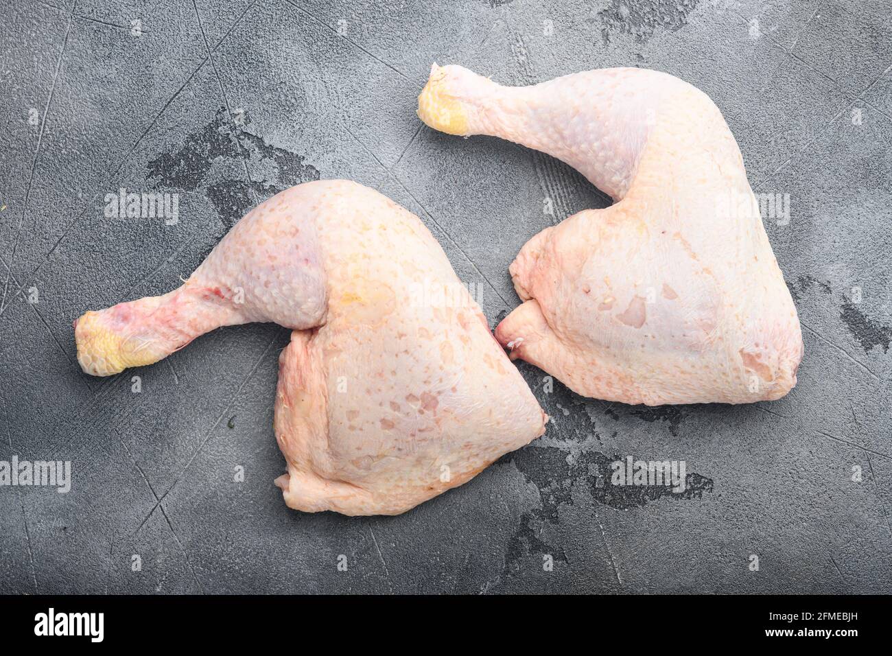 Raw chicken leg quarters, legs meat on bone set, on gray stone ...