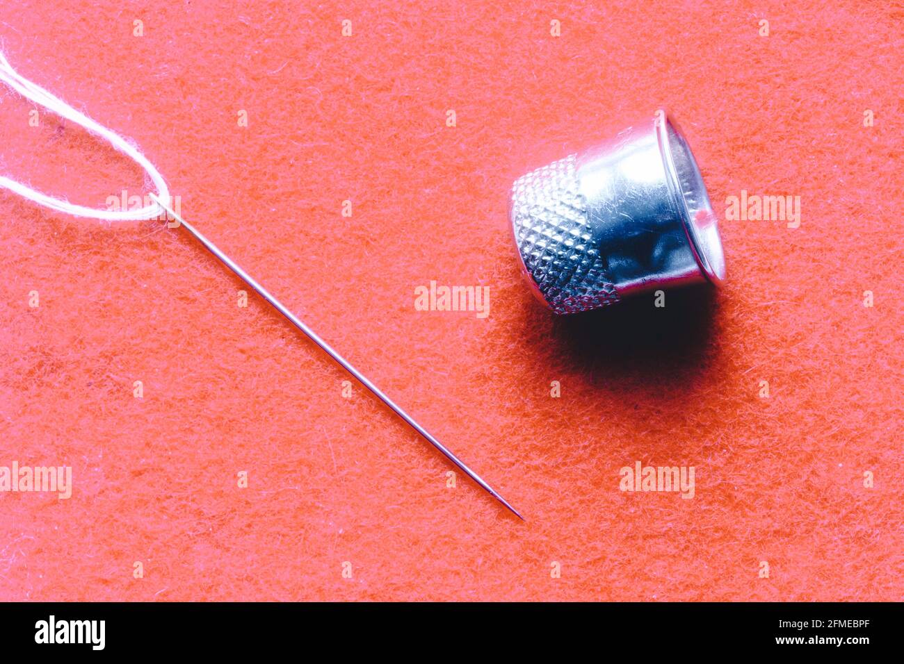 Needle with thread and a metal thimble, USA Stock Photo - Alamy