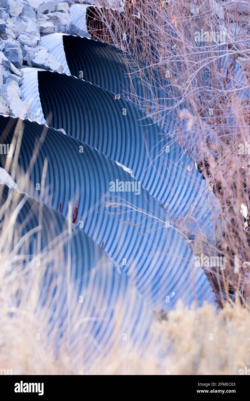 Five parallel pipes lie in a drainage ditch ready for heavy rain and ...
