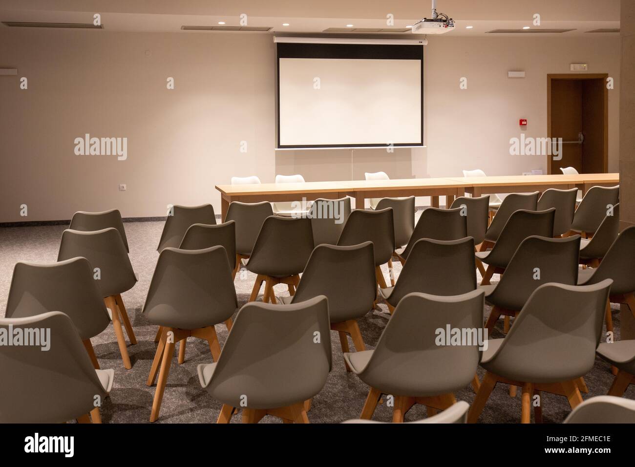 Interior of an empty hotel hall with chairs spaced close to each other ...
