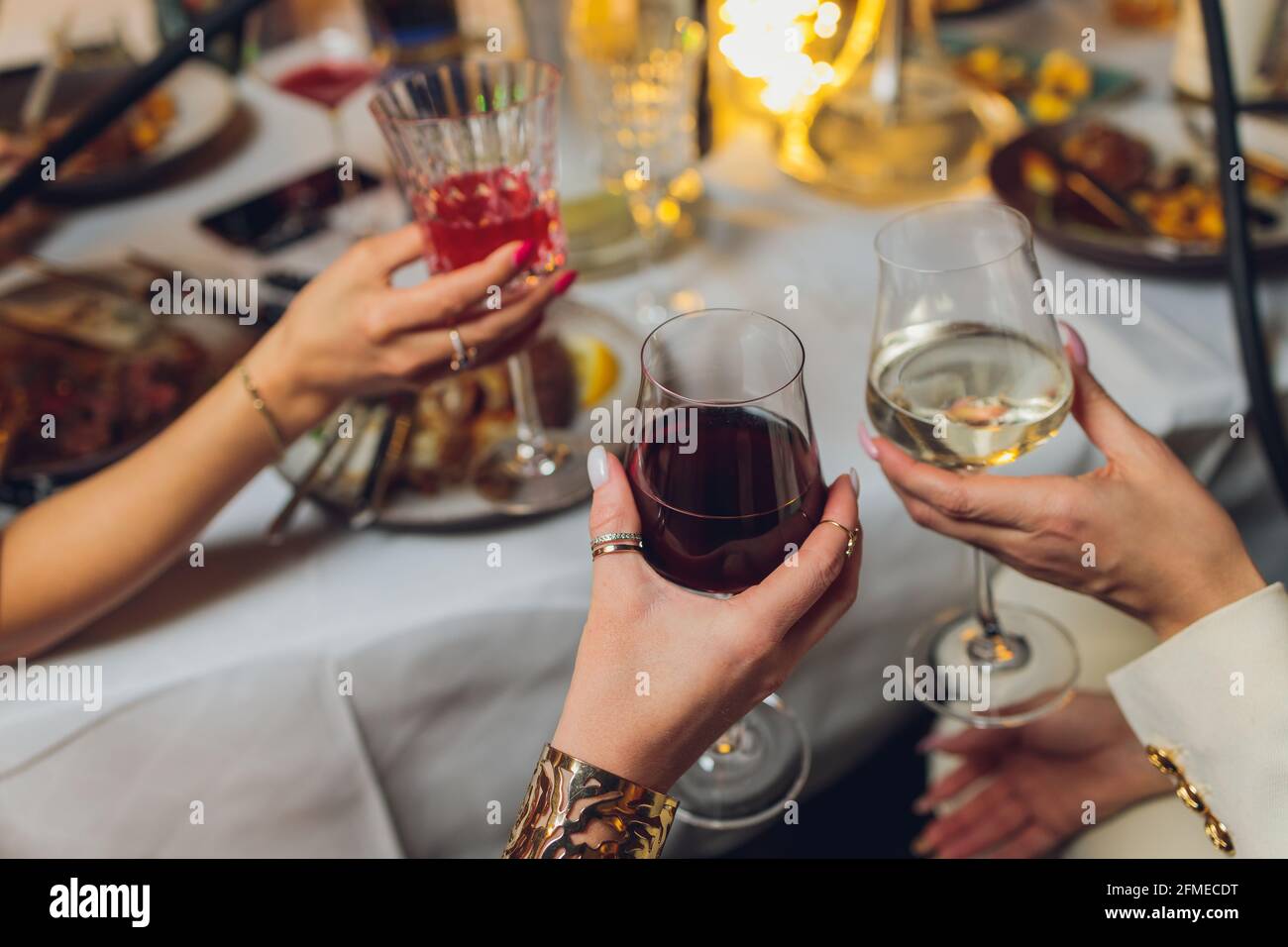 Clinking glasses with alcohol and toasting, party Stock Photo - Alamy