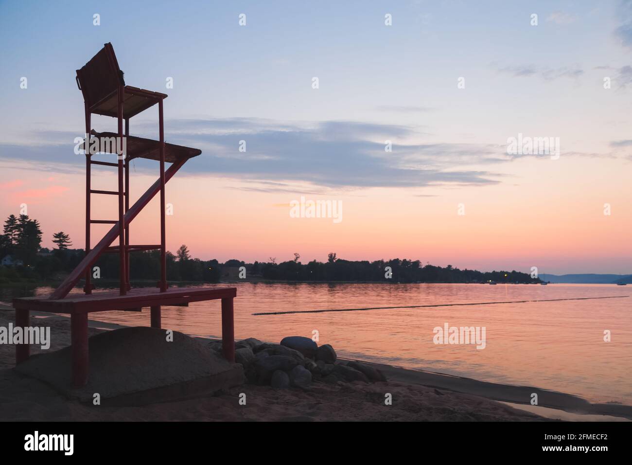 Silhouette of an empty red lifeguard chair during idyllic sunset or ...
