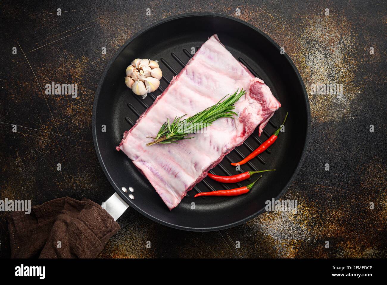 Fresh rack of raw pork spare ribs seasoned with spices set, in cast ...