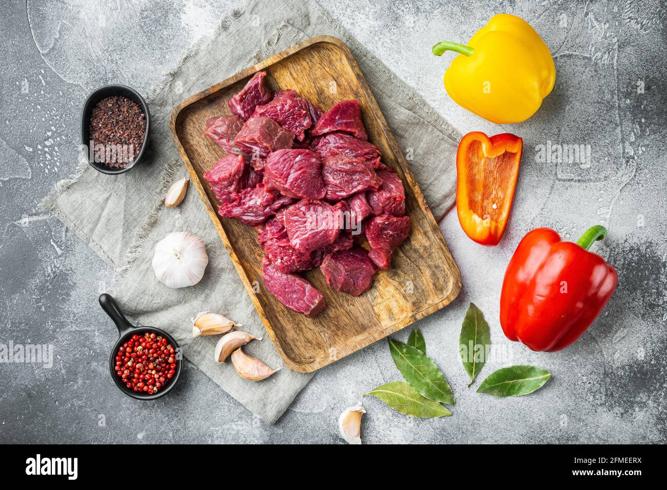 Fresh raw chopped beef with sweet bell pepper, on gray stone background ...
