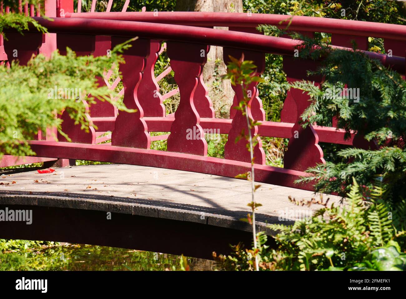 red wooden railing of a japanese stone footbridge in the sunlight Stock ...