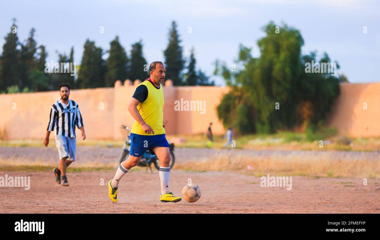 Marrakech, Morocco - 25 APRIL 2021 : Men playing football on a dusty ...