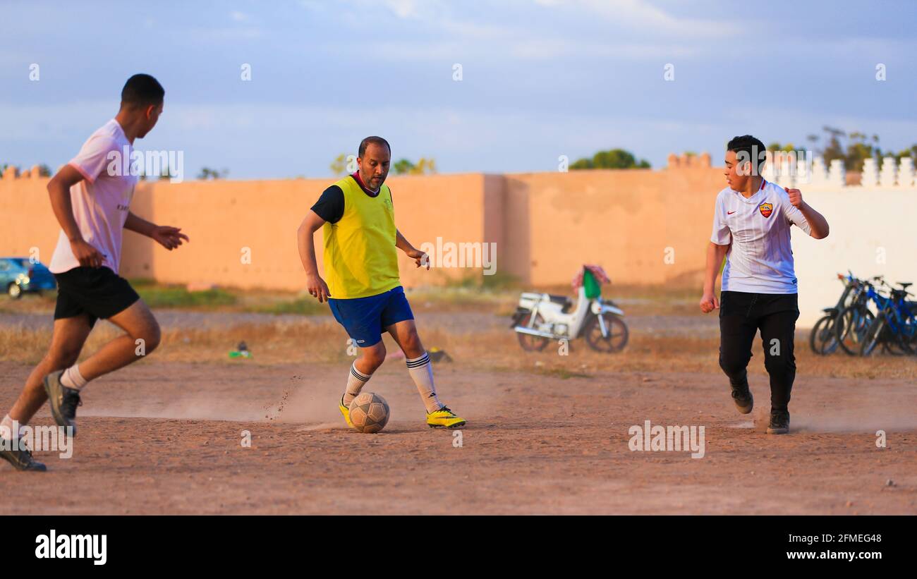 Marrakech, Morocco - 25 APRIL 2021 : Men playing football on a dusty ...