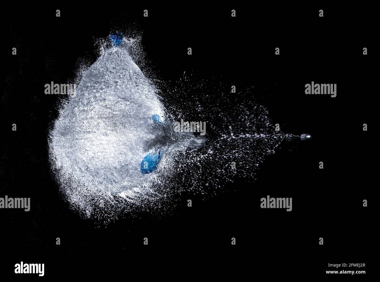 explosion of a water filled balloon on a black background, shot through ...