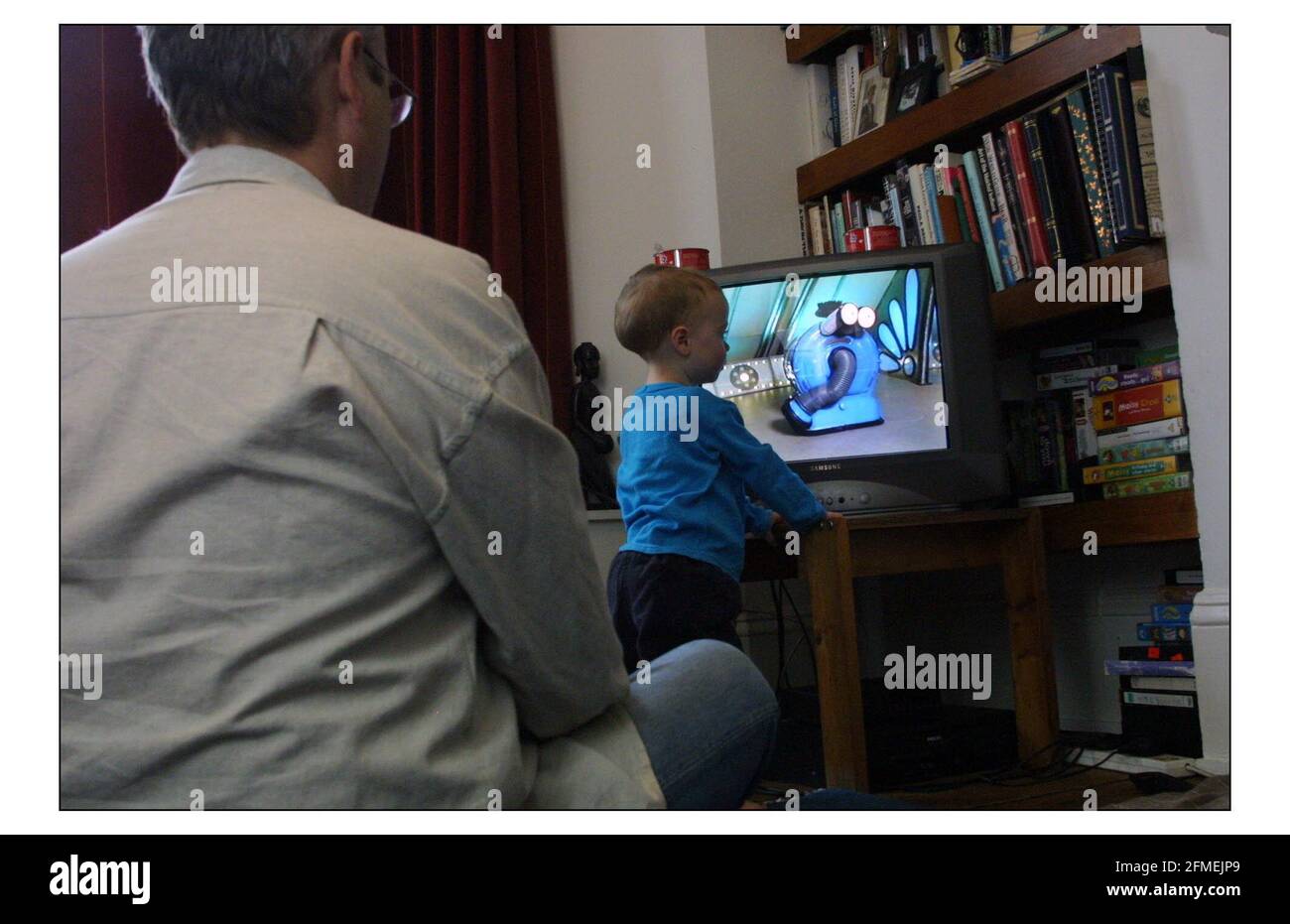 Oliver Bennett watching Tv with his son Bruno.pic David Sandison 30/10 ...
