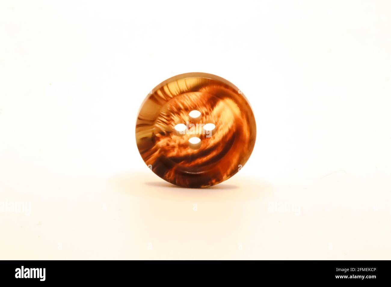 A macro photo of a striped four hole clothes button isolated against a ...