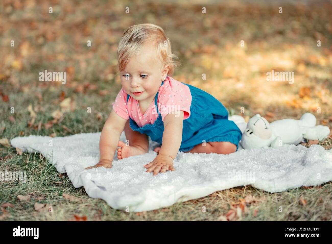 Cute baby girl crawling on ground in park outdoor. Child toddler ...