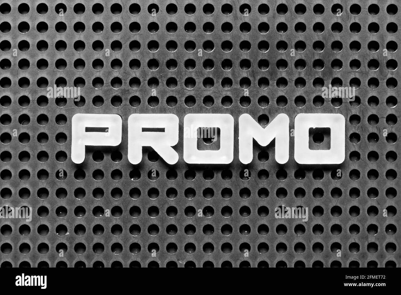 White alphabet letter in word promo on black pegboard background Stock ...