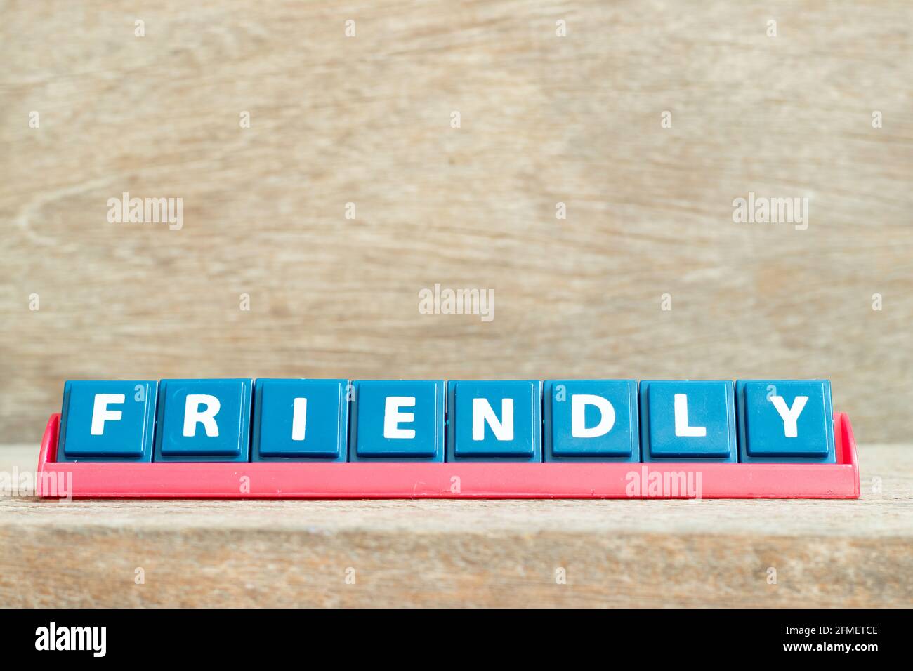 Tile alphabet letter with word friendly in red color rack on wood ...