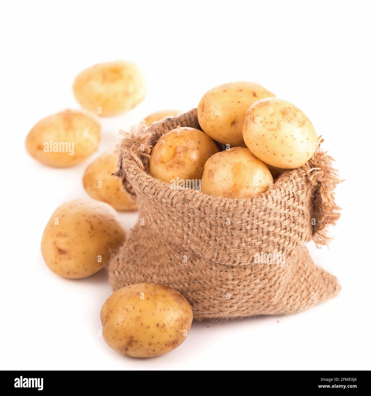 Raw potatoes in burlap bag isolated on white background Stock Photo - Alamy